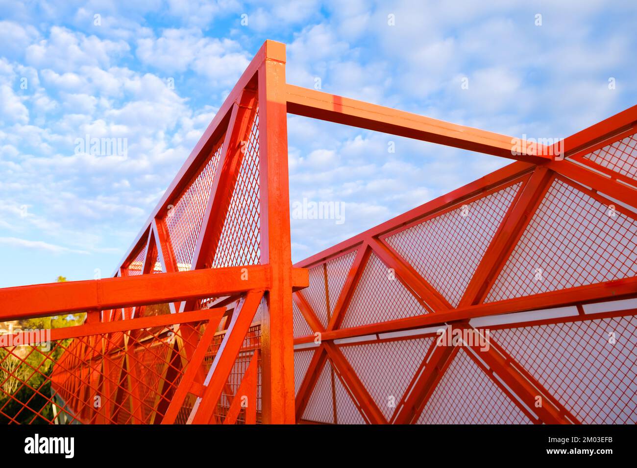 For pedestrian safety, a fenced-in metal walkway crosses over a road ...