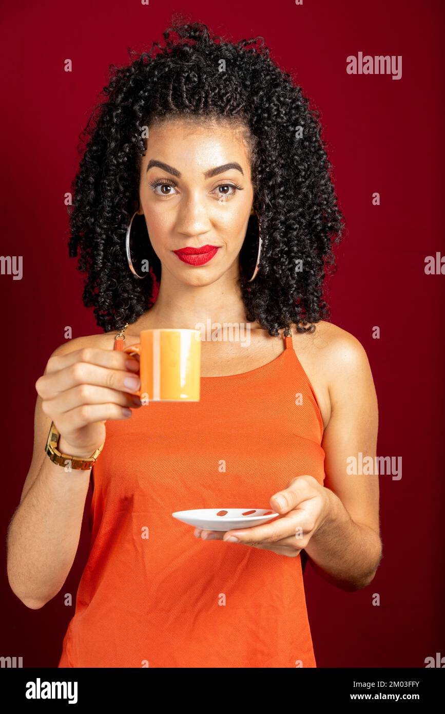 Portrait of young beautiful woman, holding cup of coffee, wearing ...