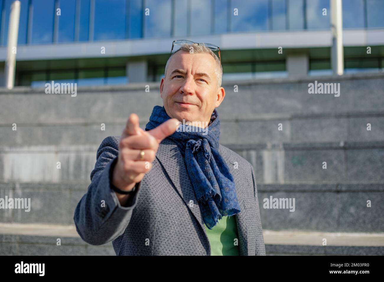 Portrait of middle-aged man standing near concrete stairs of modern ...