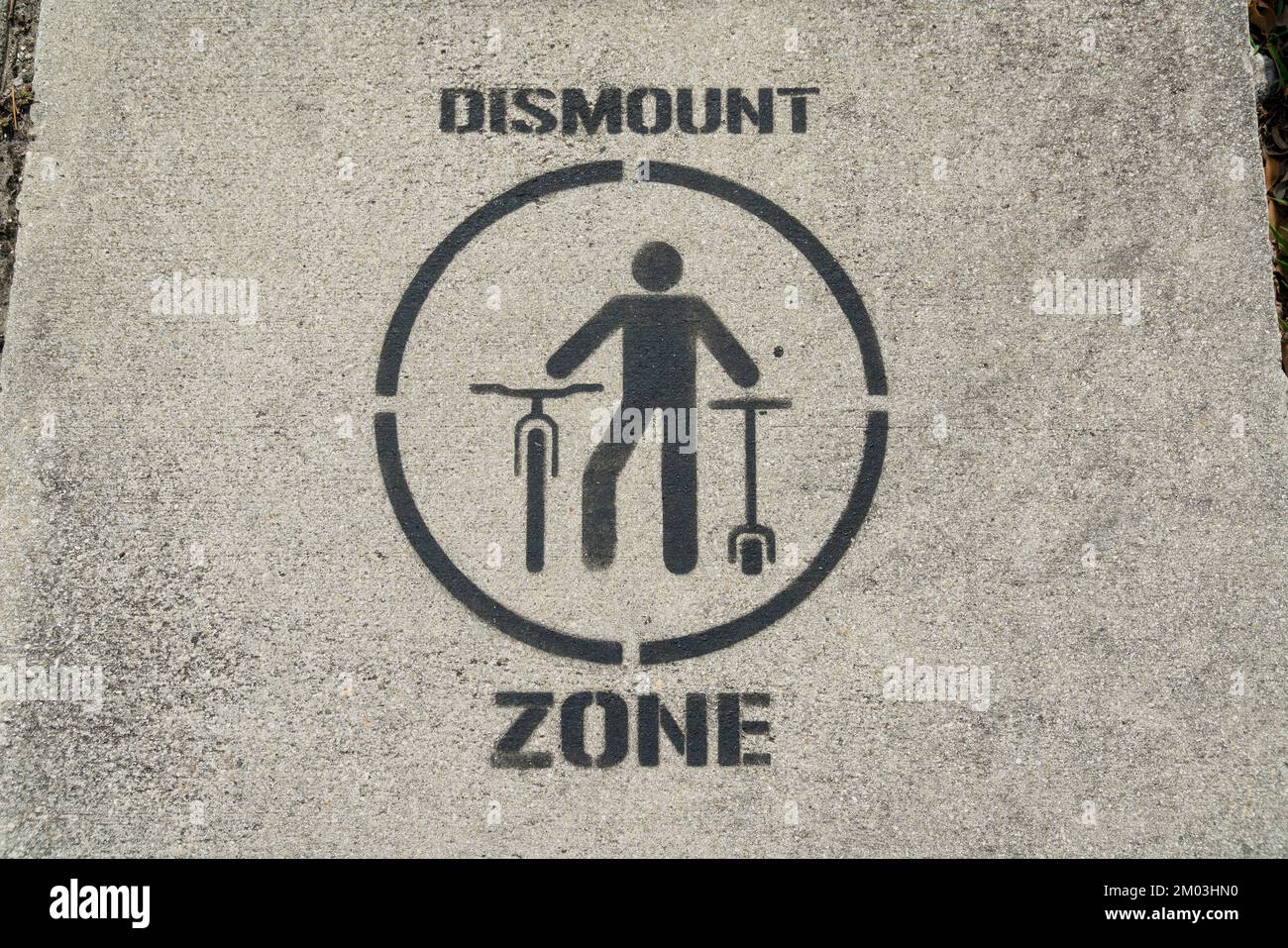 Dismount zone painted sign over the bridge at Miami, Florida. Dismount ...