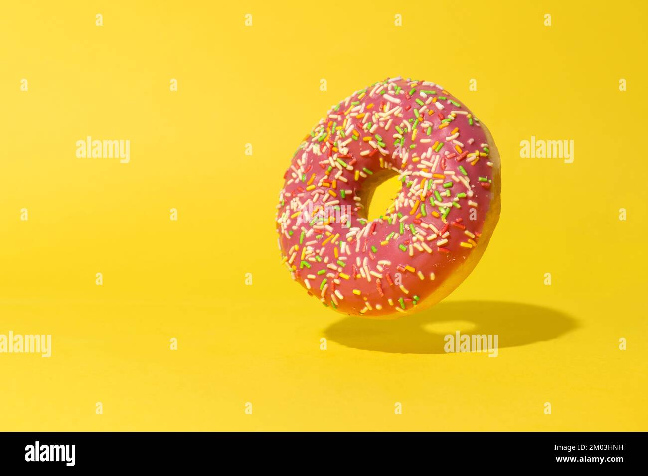 Levitating pink donut on yellow background. Creative food background ...
