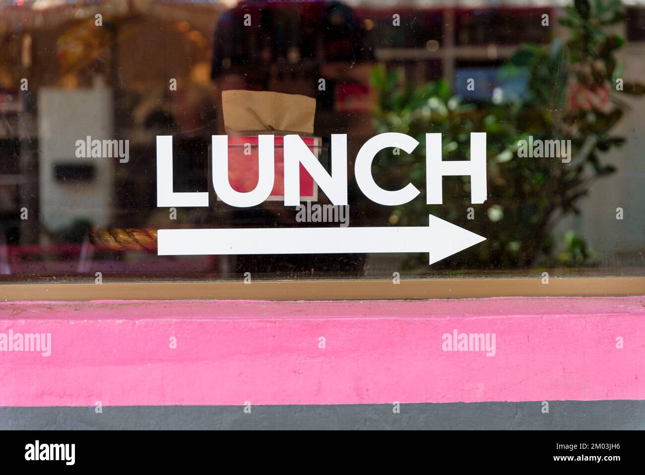Painted Lunch and arrow symbol sign on a clear glass wall at Miami ...
