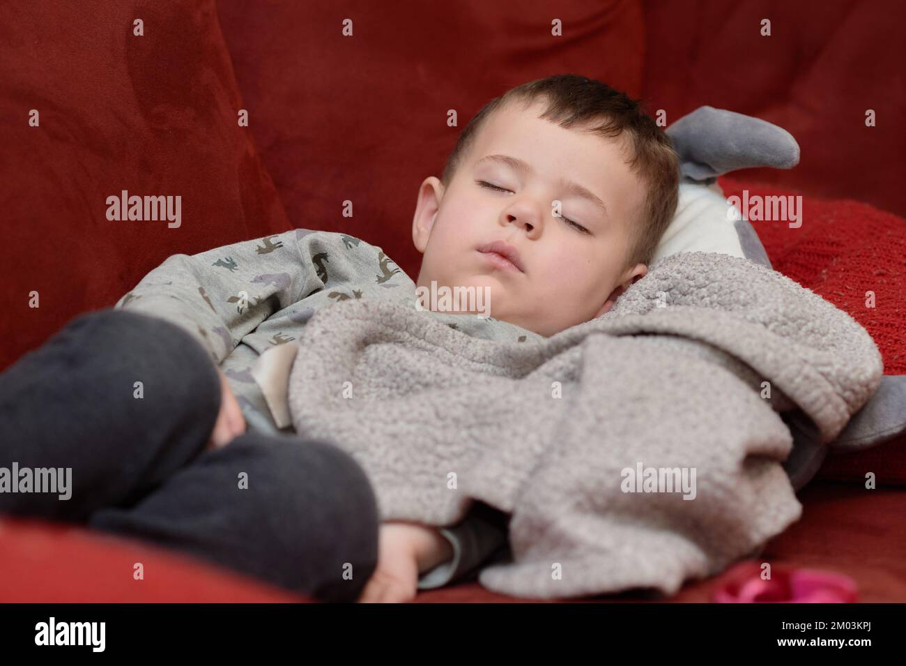 cute boy sleeping on the couch after a meal Stock Photo - Alamy