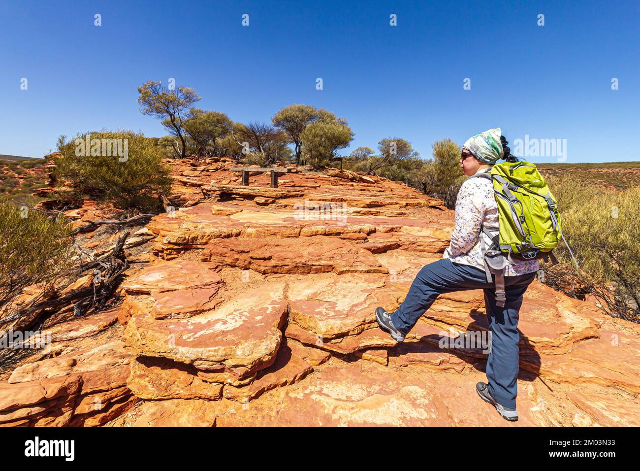 Lone woman hiker scrambling up on sandstone rock surface of Nature ...