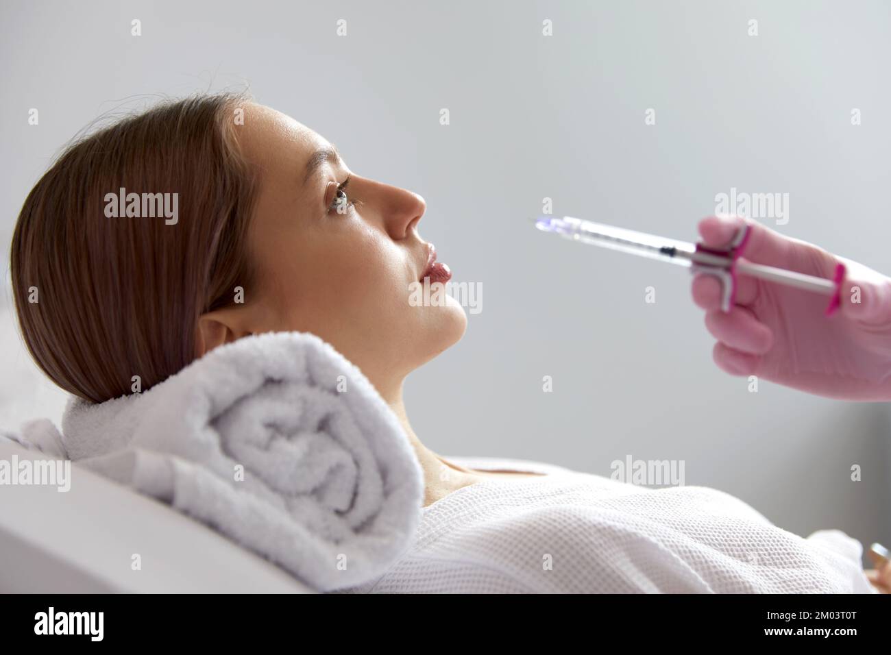 Side view of Doctor cosmetologist makes the Rejuvenating facial ...