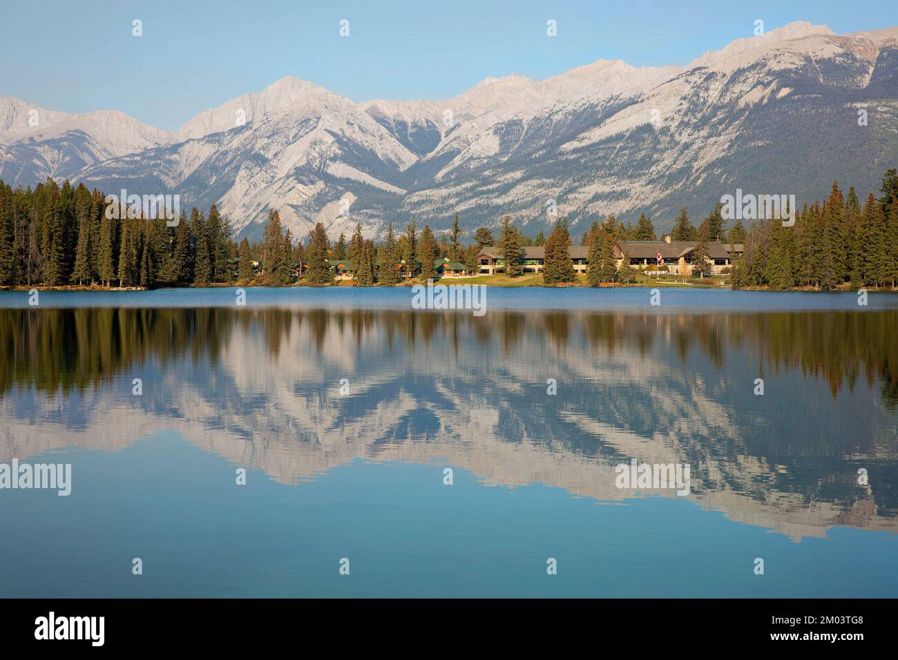 Fairmont Jasper Park Lodge with a reflection of the Rocky Mountains in ...