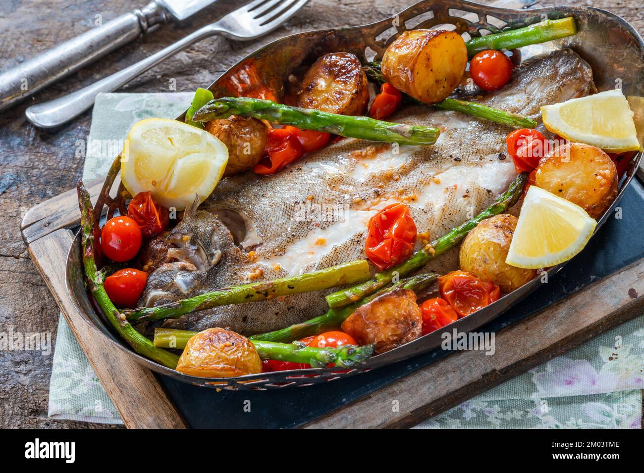 Lemon sole baked with potatoes, baby tomatoes and asparagus Stock Photo ...