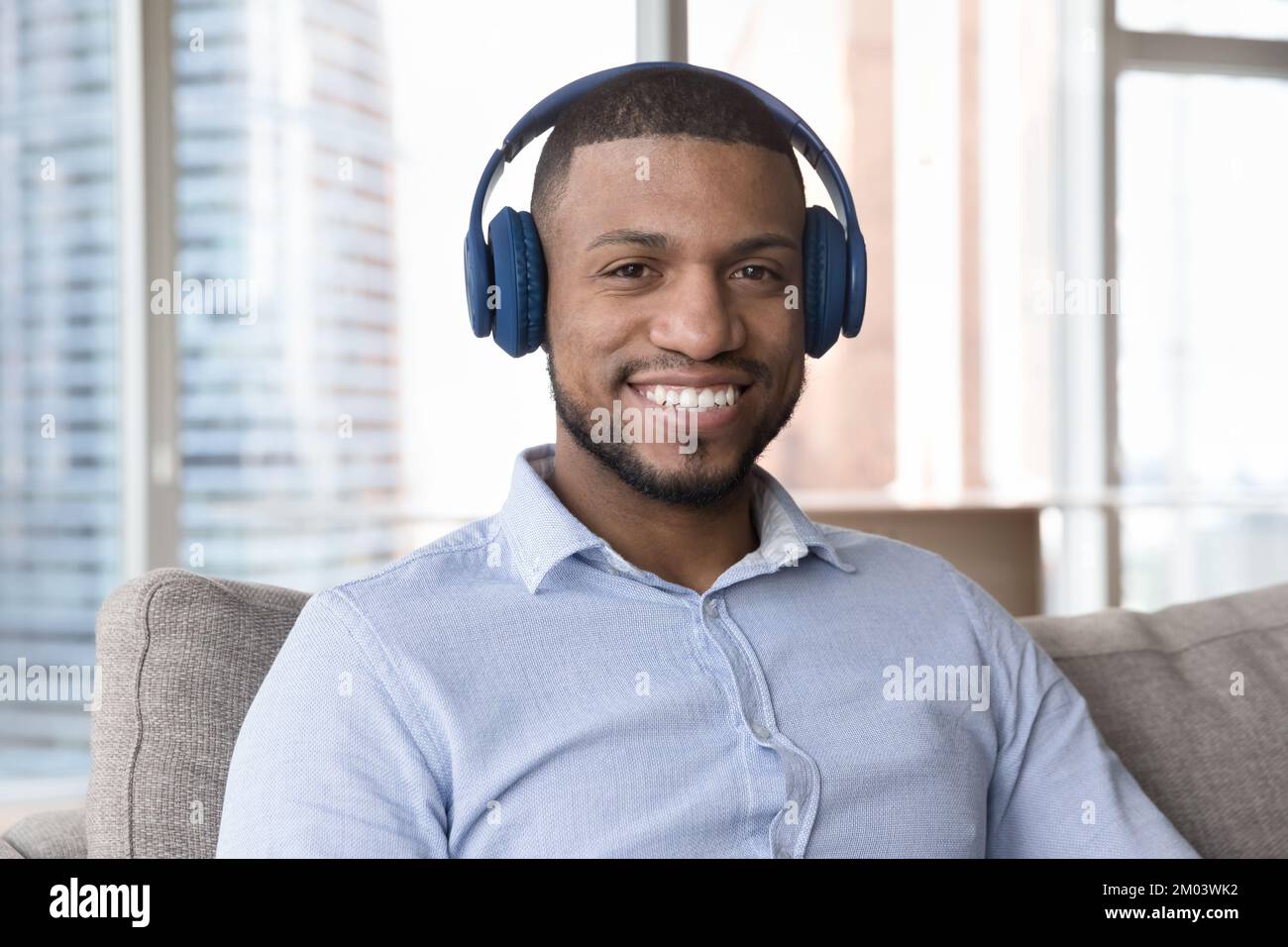 Happy handsome young Black business man in wireless head phones Stock ...