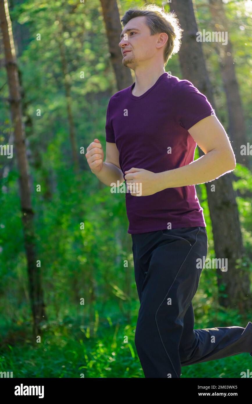 Running man jogging in city park at beautiful summer day. Sport fitness ...
