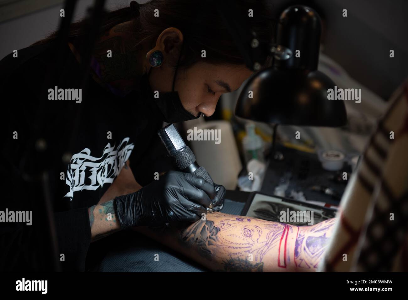 Bangkok, Thailand. 3rd Dec, 2022. A tattoo artist puts tattoos on the ...