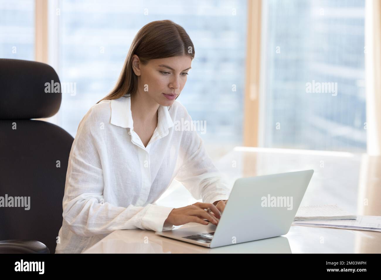 Focused young employee woman working at computer at office table Stock ...