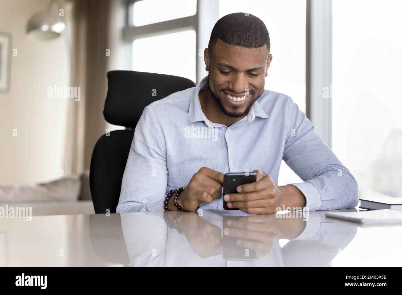 Happy millennial African office employee man reading, typing text ...