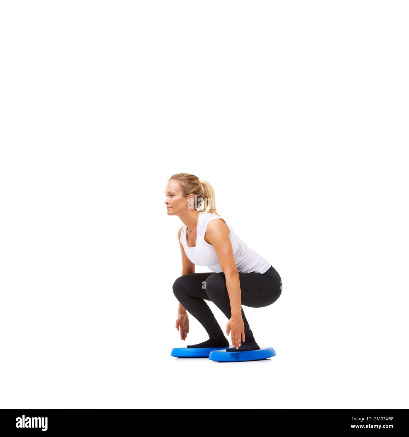 Working her thighs. Full length studio shot of a woman doing crouching ...