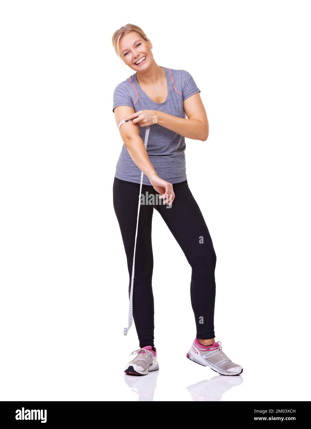 Build those biceps. Studio shot of an attractive young woman measuring ...