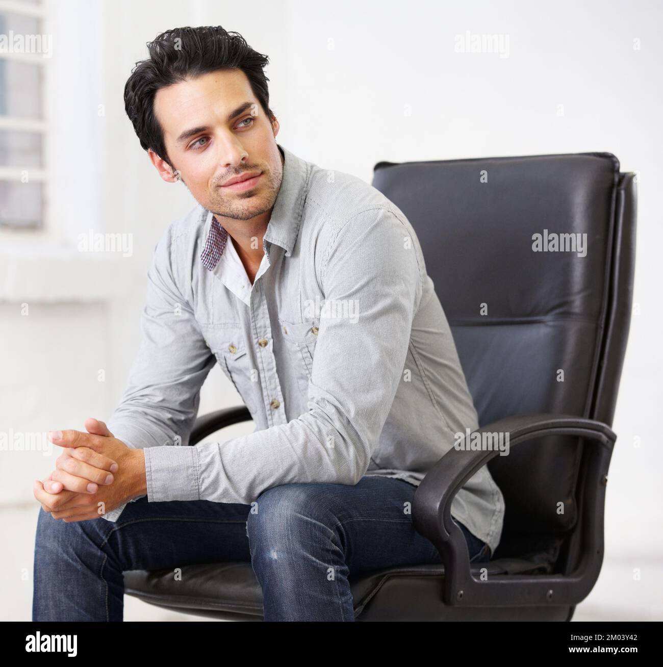 Dashing and debonair. a handsome young sitting in a chair Stock Photo ...