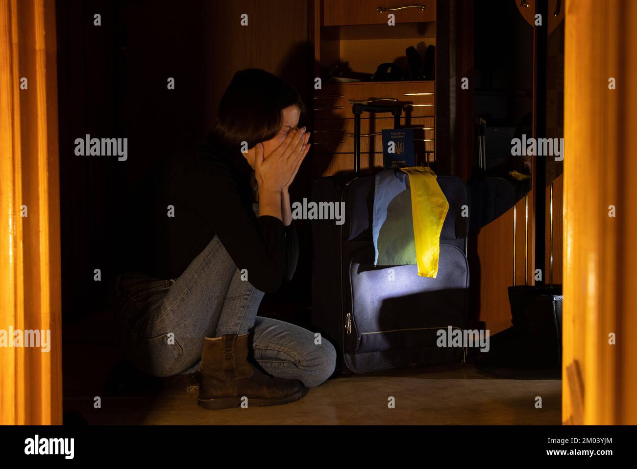 Ukrainian woman crying near a suitcase with the flag of Ukraine and a ...