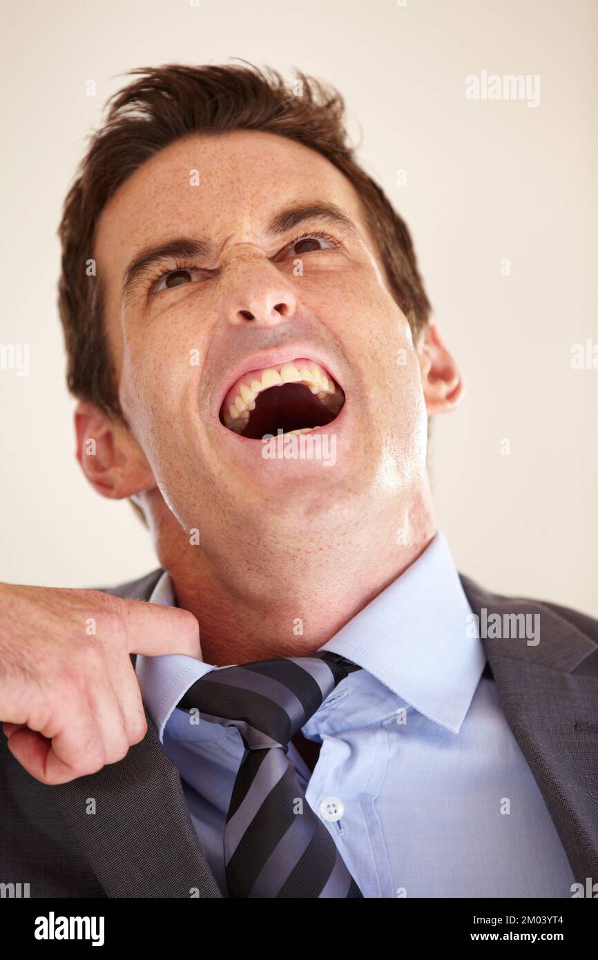 Business stress is choking him. A handsome young man pulling at his ...