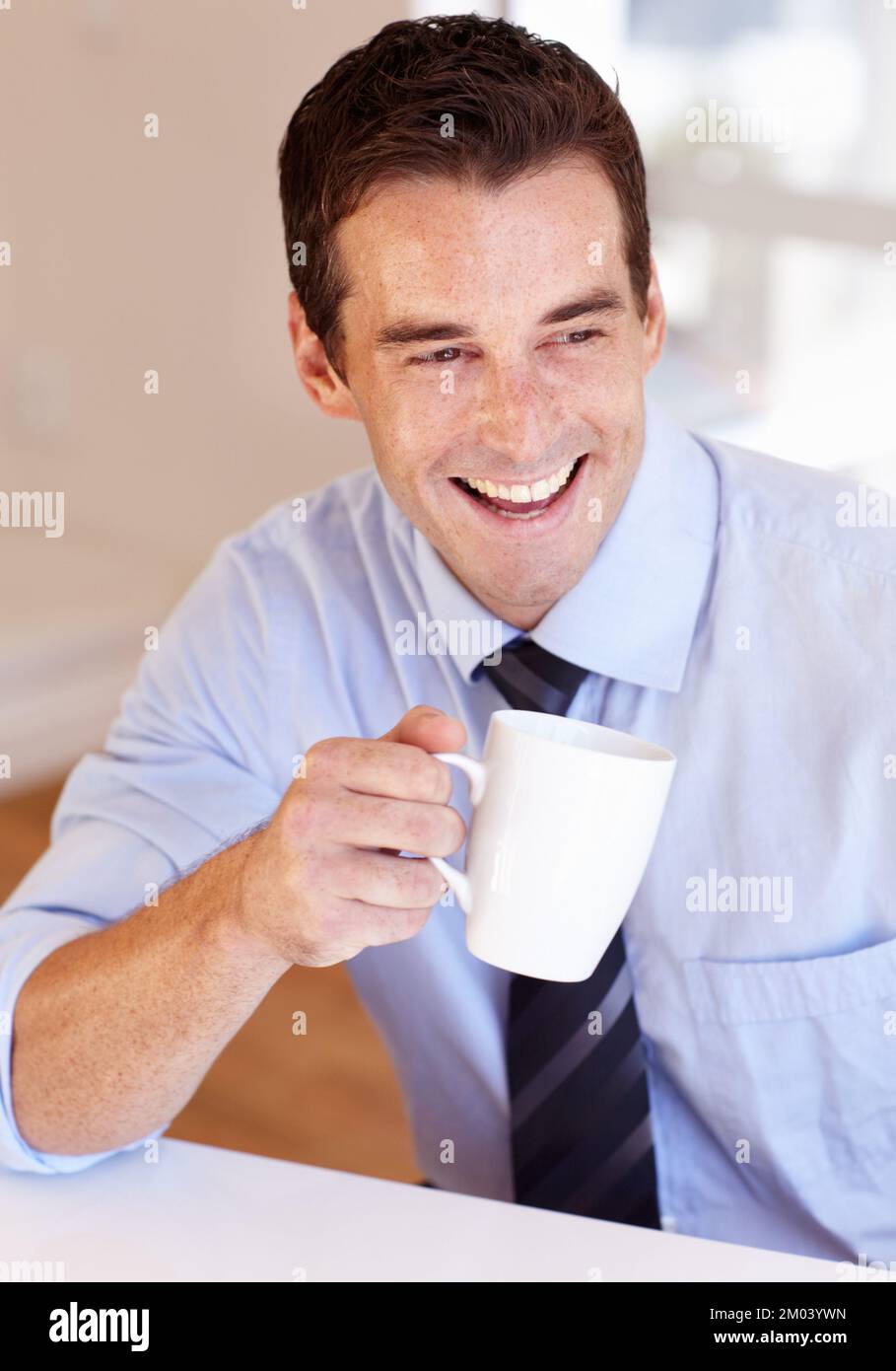 Starting his work day with a smile. Smiling young businessman enjoying ...
