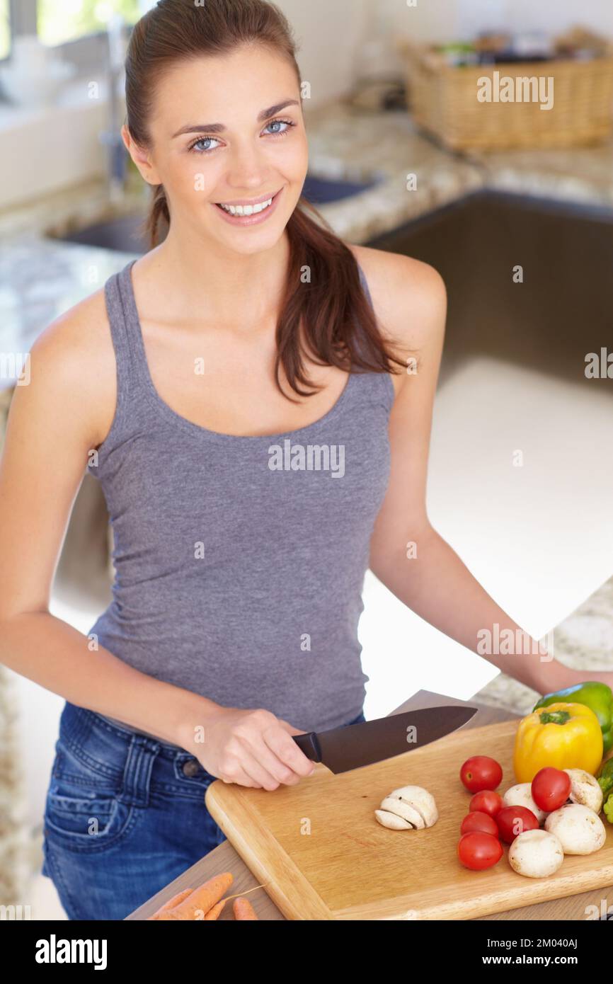 She cooks like a pro. Portrait of an attractive young woman cutting ...