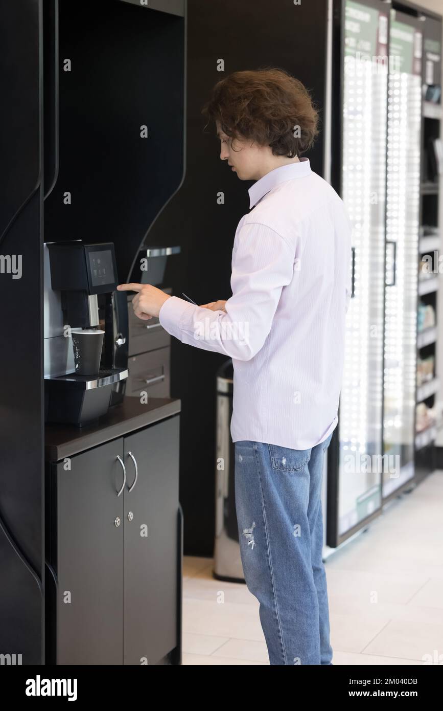 Young man prepare coffee using professional vending machine Stock Photo ... Young man prepare coffee using professional vending machine Stock Photo ...