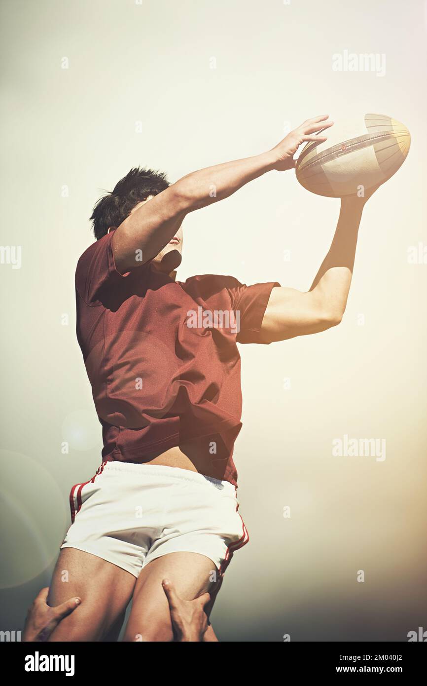 Securing the ball. a young rugby player catching the ball during a ...