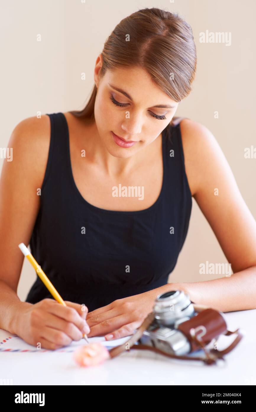 Sending pictures to gran. A gorgeous young woman writing the address on ...