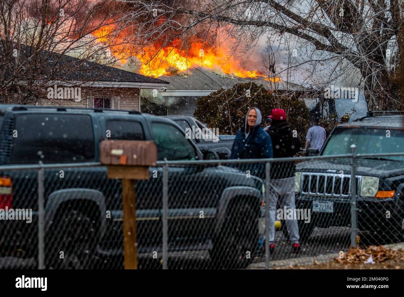Neighbors watch the flames of a structure fire. Two unoccupied homes ...