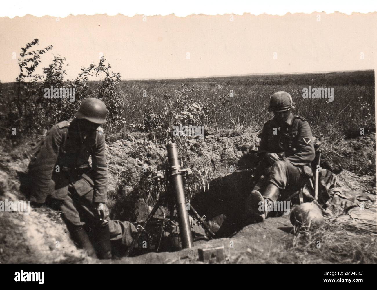 German Army 8cm. Mortar Crew rest in their Mortar emplacement on the ...