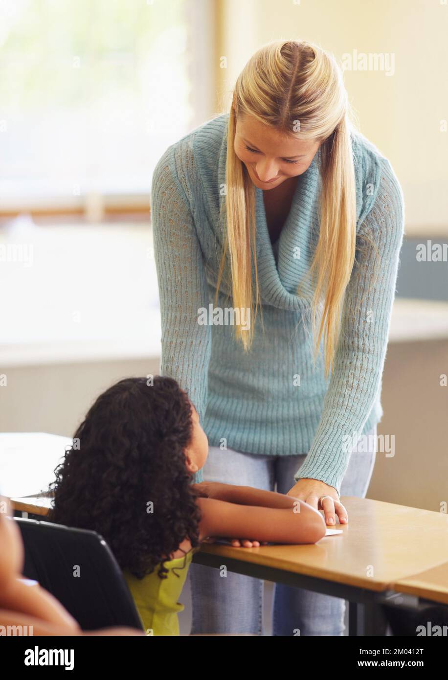 Encouraging her student. A teacher talking to a scholar in class Stock ...