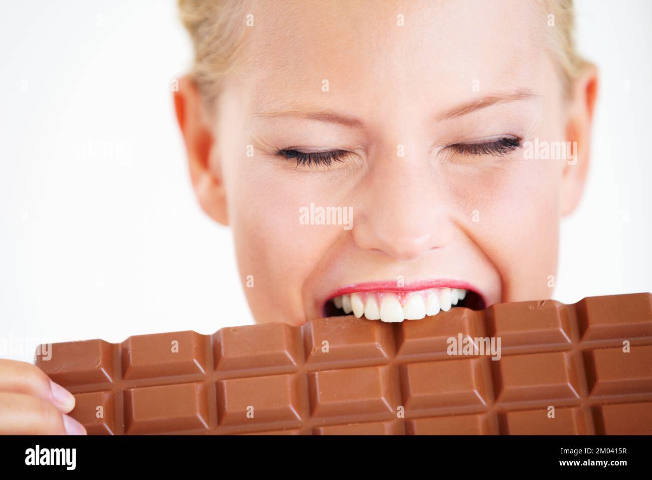 I cant resist anymore. Crazed young woman biting into a huge piece of ...