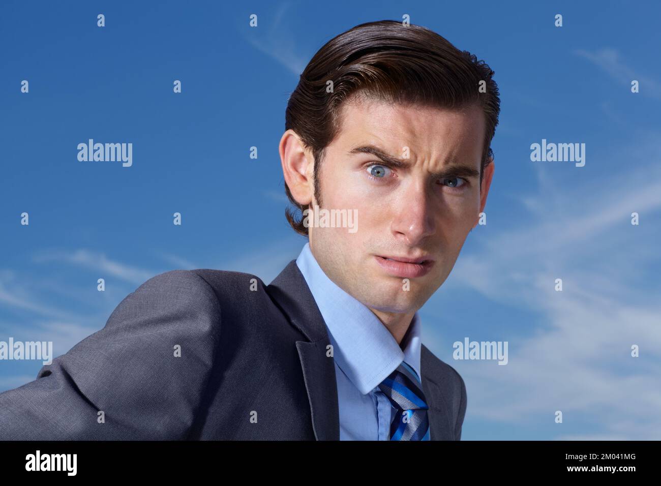 Confused young business man standing and thinking, full length portrait ...