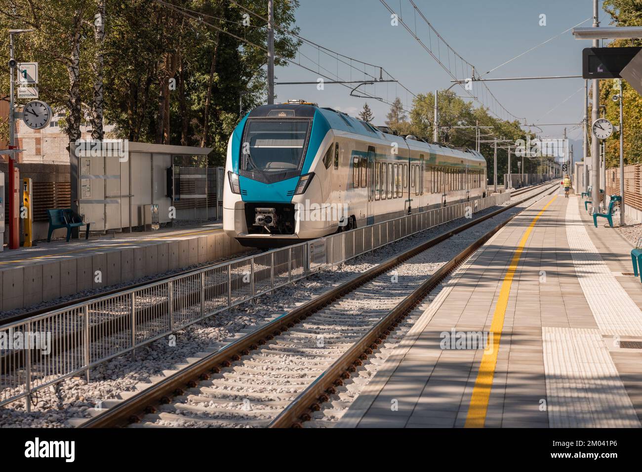 Modern passenger train in blue and white color is entering the station ...