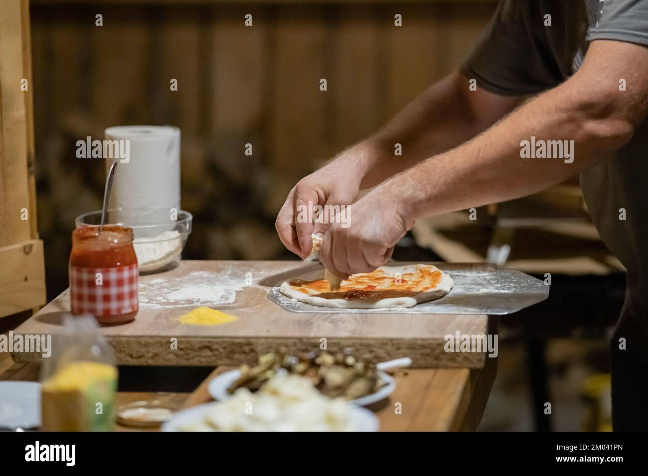 Man preparing a delicious fresh home made pizza. Person topping pizza ...
