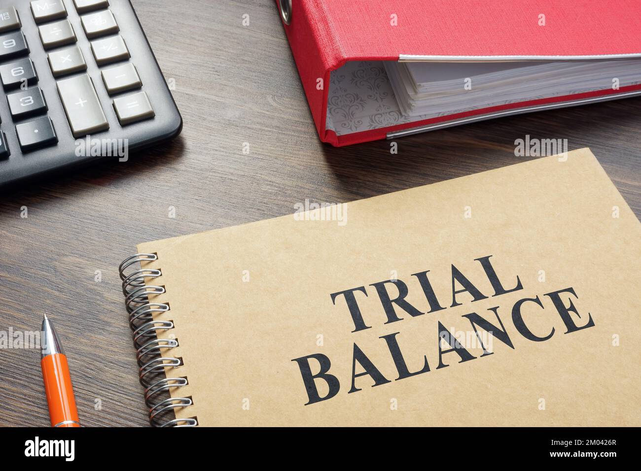 Trial balance book near red folder and calculator Stock Photo - Alamy
