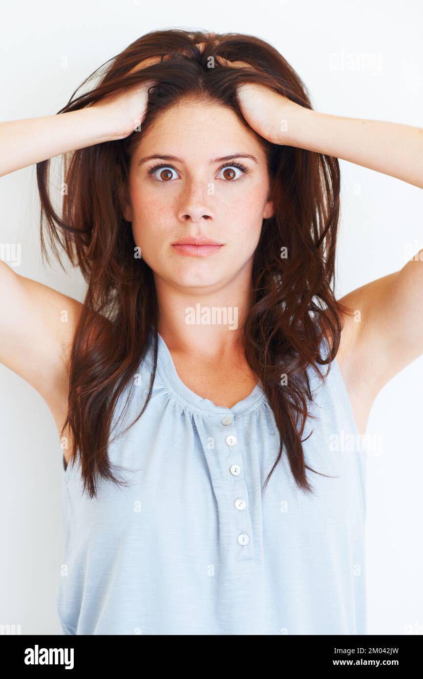 Crazy hair day. Pretty young woman looking disturbed while running her ...