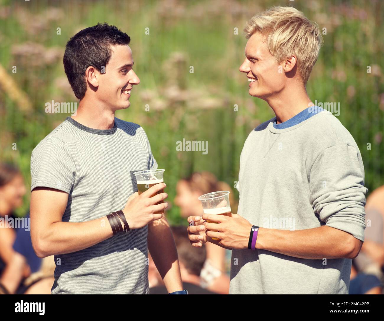 Cheers, buddy. two male friends talking while drinking beer at an ...