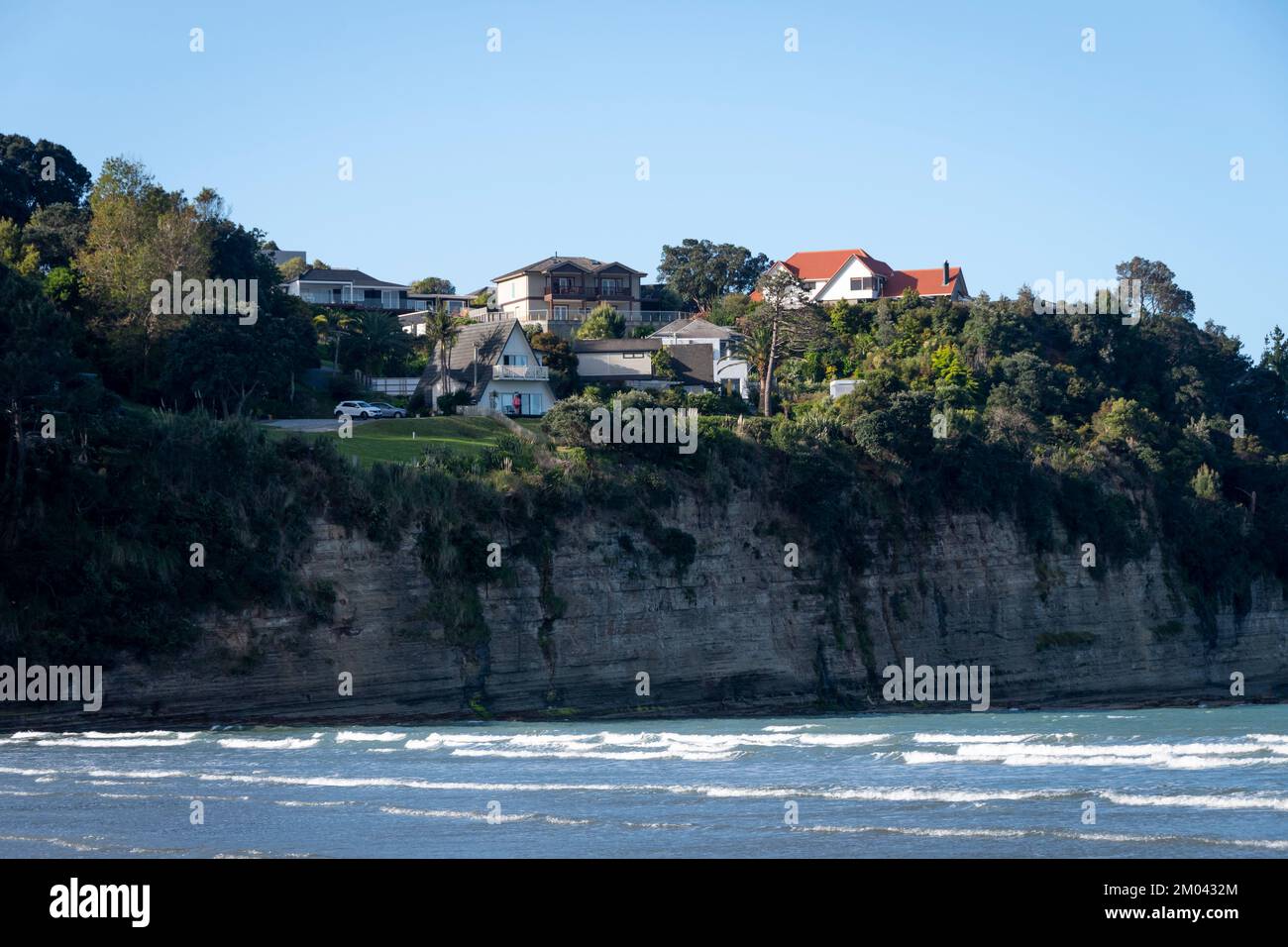 Houses on cliff above sea, Orewa, Auckland, North Island, New Zealand ...