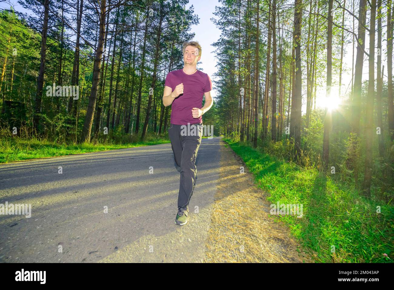 Running man jogging in city park at beautiful summer day. Sport fitness ...