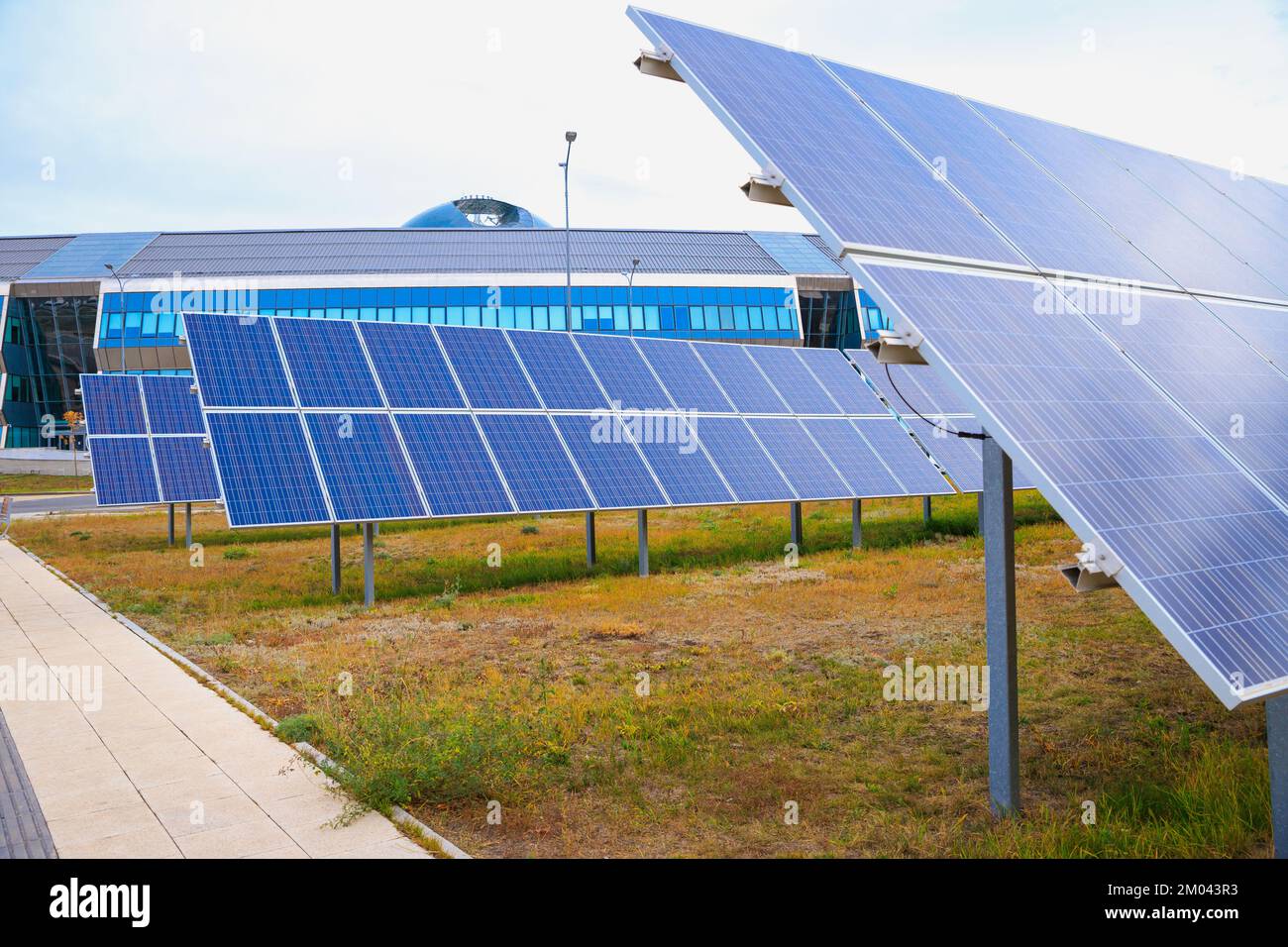 Rows of solar power panels on lawn grass in big city. Concept for using ...
