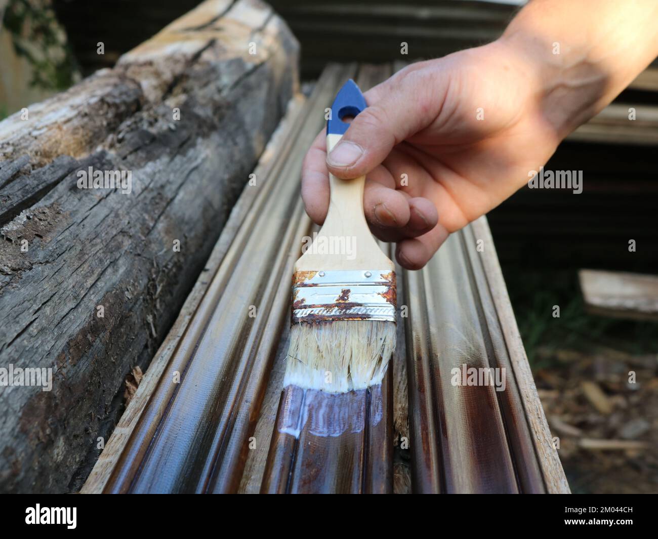 varnishing a floor plinth covered with a dark outdoor stain, applying a ...
