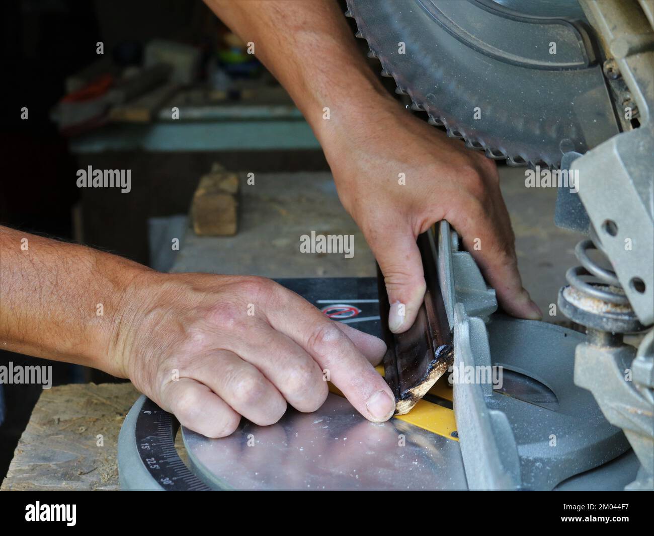 working with a miter saw in a carpenter's workshop, close-up, cutting a ...