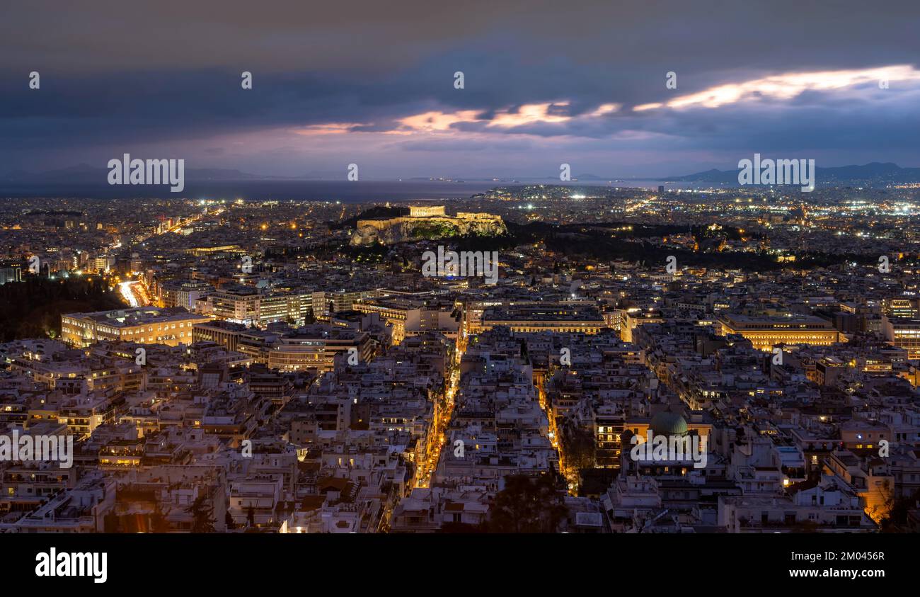 View over the sea of houses of Athens, illuminated Parthenon temple on ...