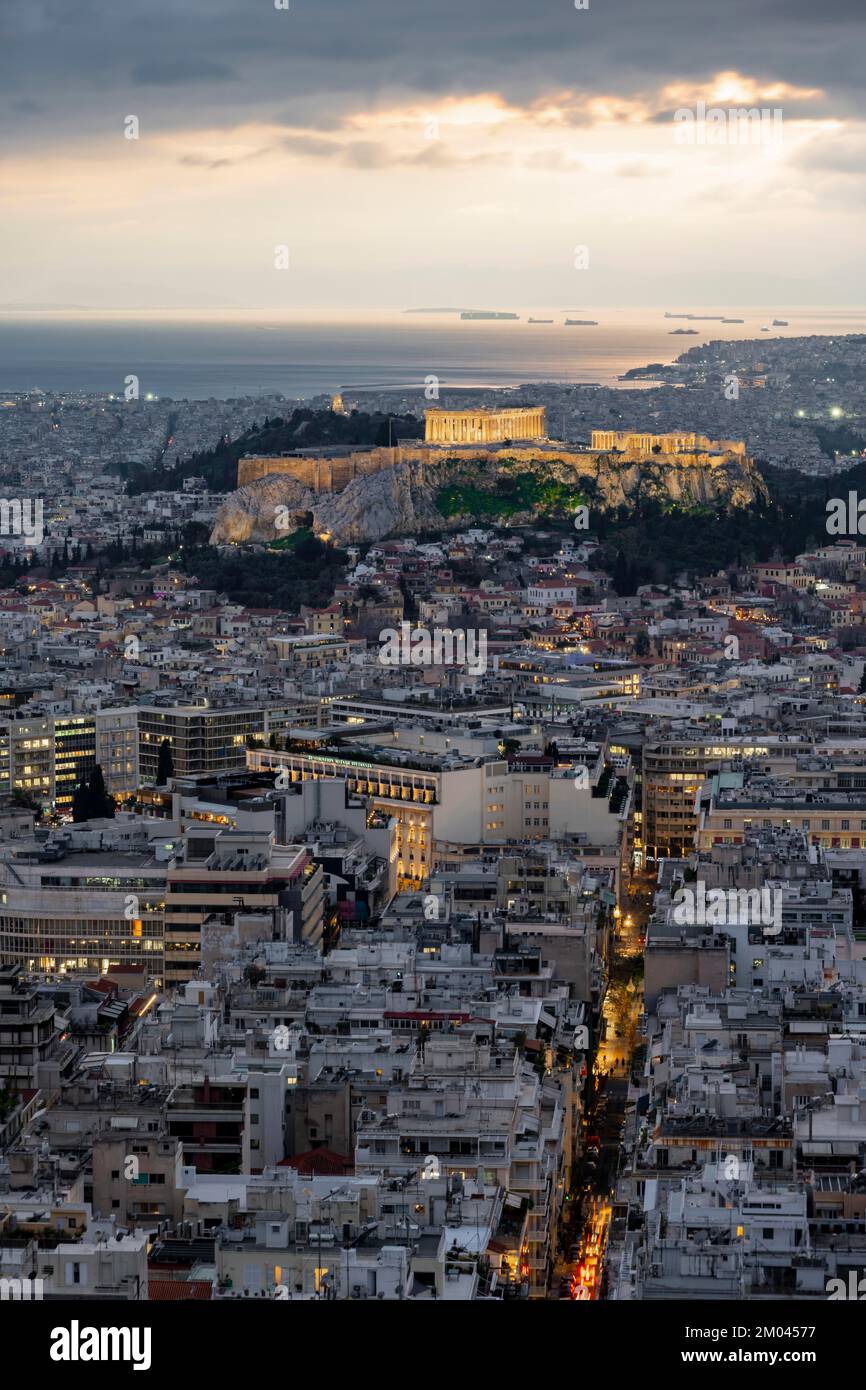 View over the sea of houses of Athens, illuminated Parthenon temple on the Acropolis, from Mount ...
