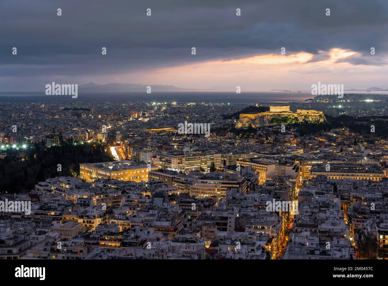 View over the sea of houses of Athens, illuminated Parthenon temple on the Acropolis, from Mount ...