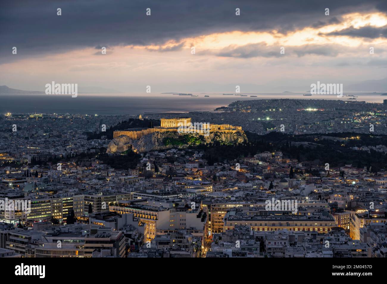 View over the sea of houses of Athens, illuminated Parthenon temple on the Acropolis, from Mount ...