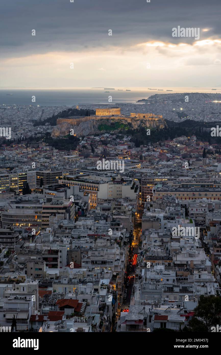 View over the sea of houses of Athens, illuminated Parthenon temple on the Acropolis, from Mount ...