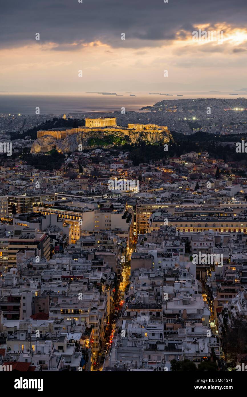 View over the sea of houses of Athens, illuminated Parthenon temple on the Acropolis, from Mount ...