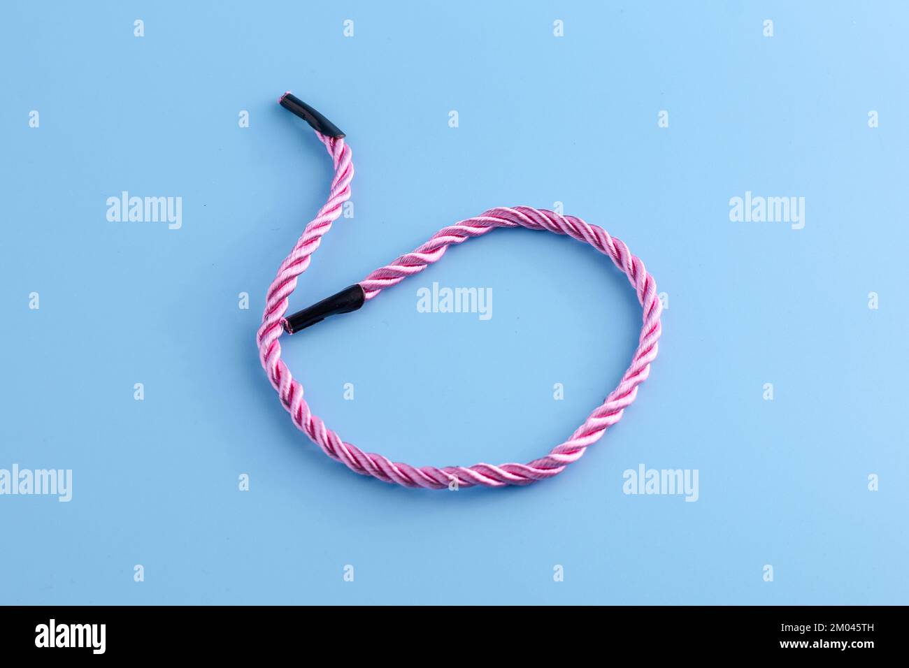 Blue background picture with a pastel pink rope Stock Photo - Alamy