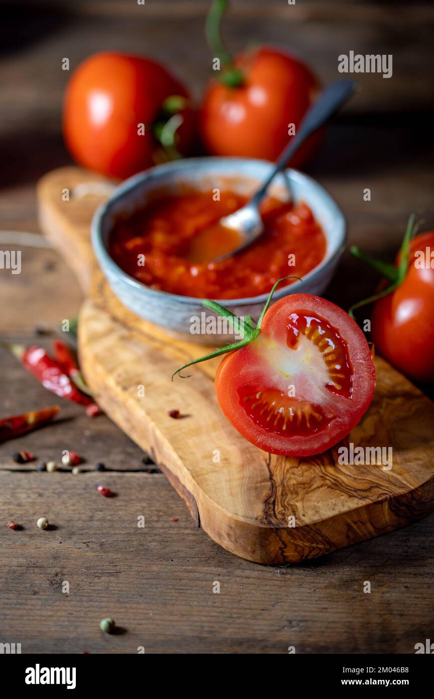 Strained tomatoes in small bowls on rustic cutting board Stock Photo ...