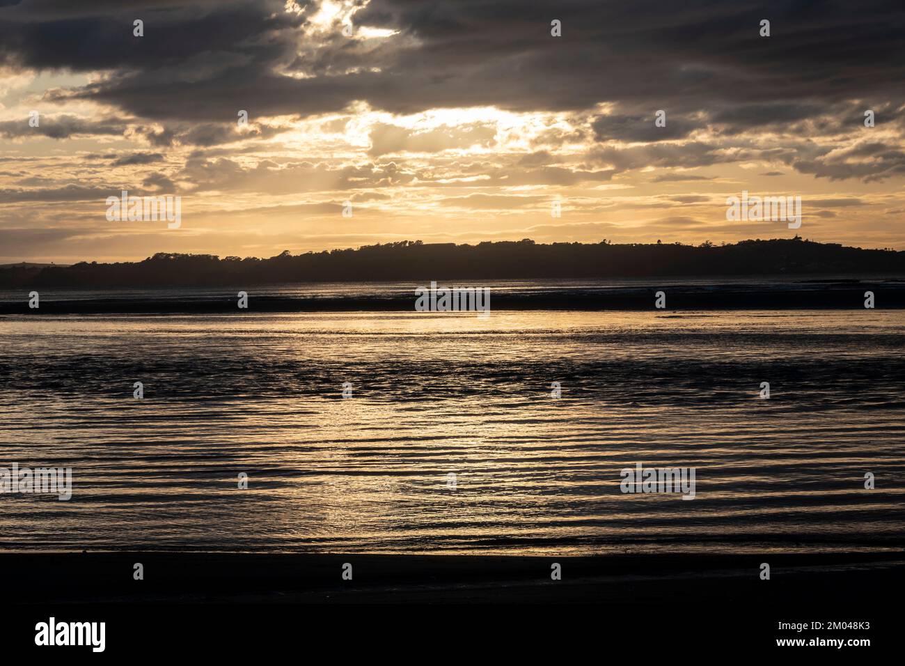 Early morning sunshine on beach and sea, Orewa, Auckland, North Island ...